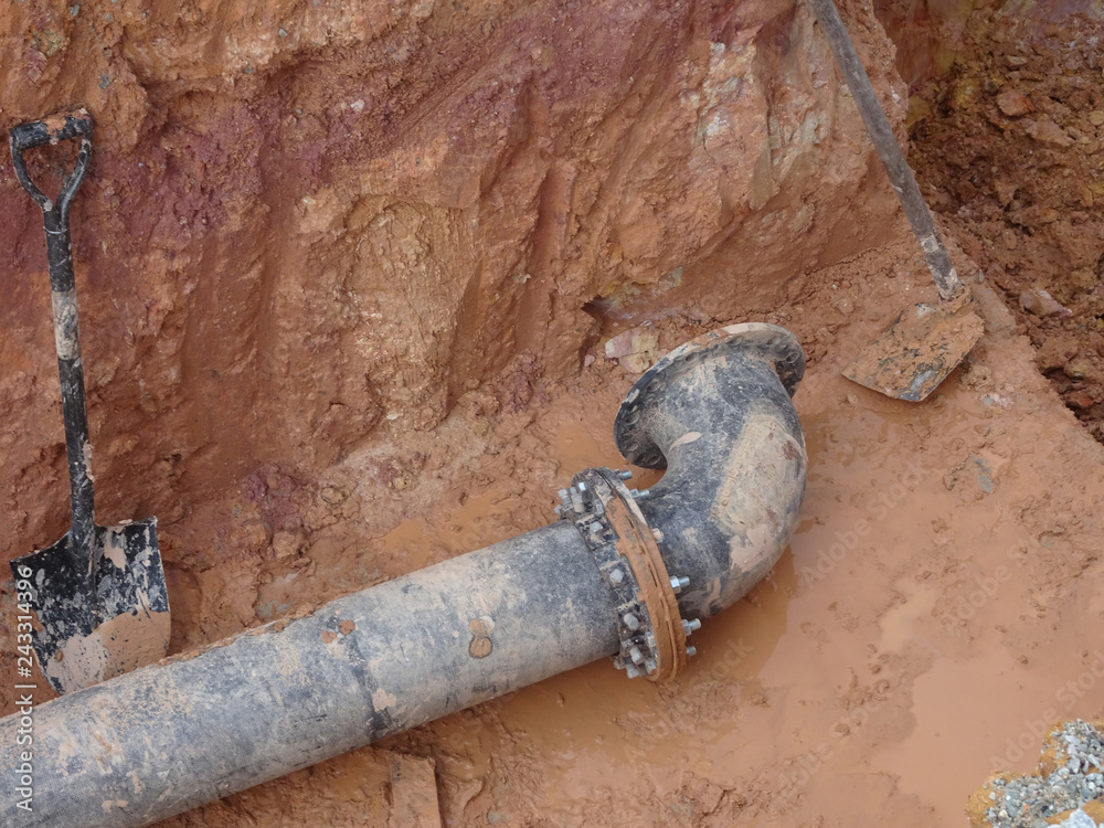 Underground utility and services pipe laid by workers in the trenches ...