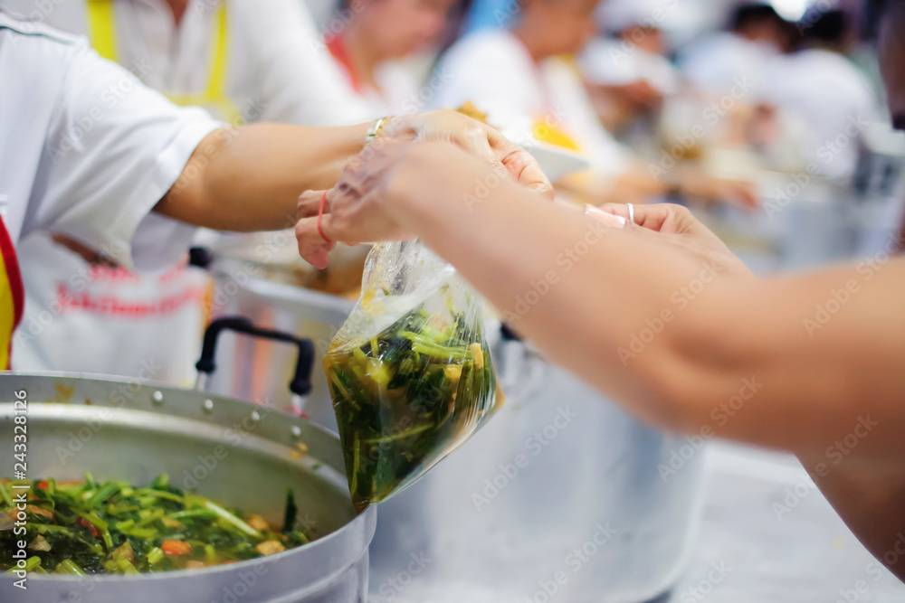 The hands of the poor bring the container to fill the food to bring ...