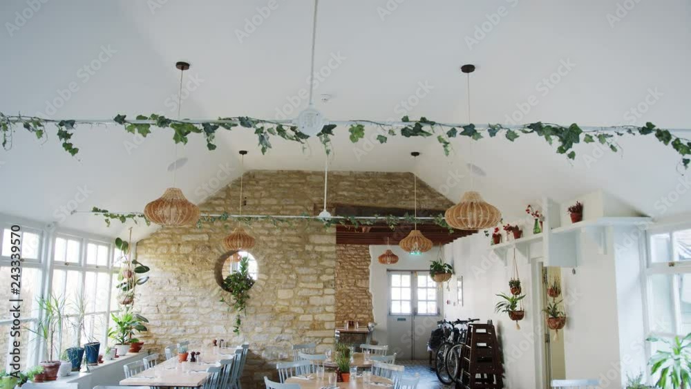 Empty tables and chairs in a restaurant dining space in daylight, with ...