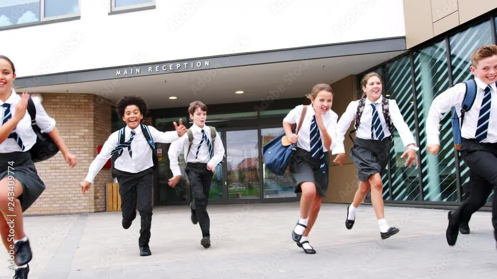 Group Of High School Students Wearing Uniform Running Out Of School ...