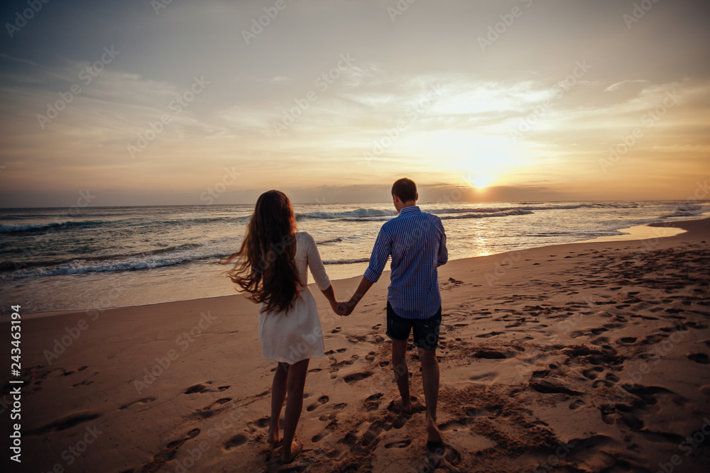 Boy And Girl Holding Hands In Sunset