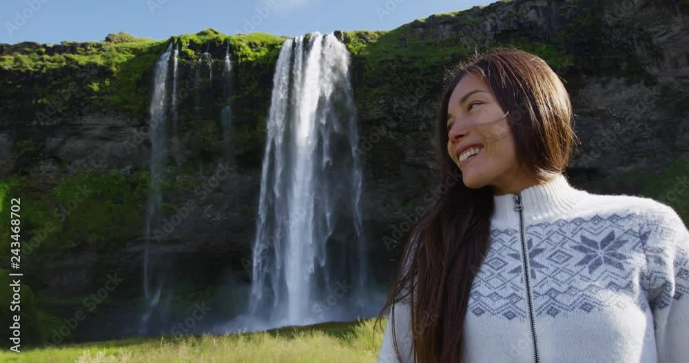 Woman on Iceland in Icelandic sweater by waterfall outdoor fun. Candid ...