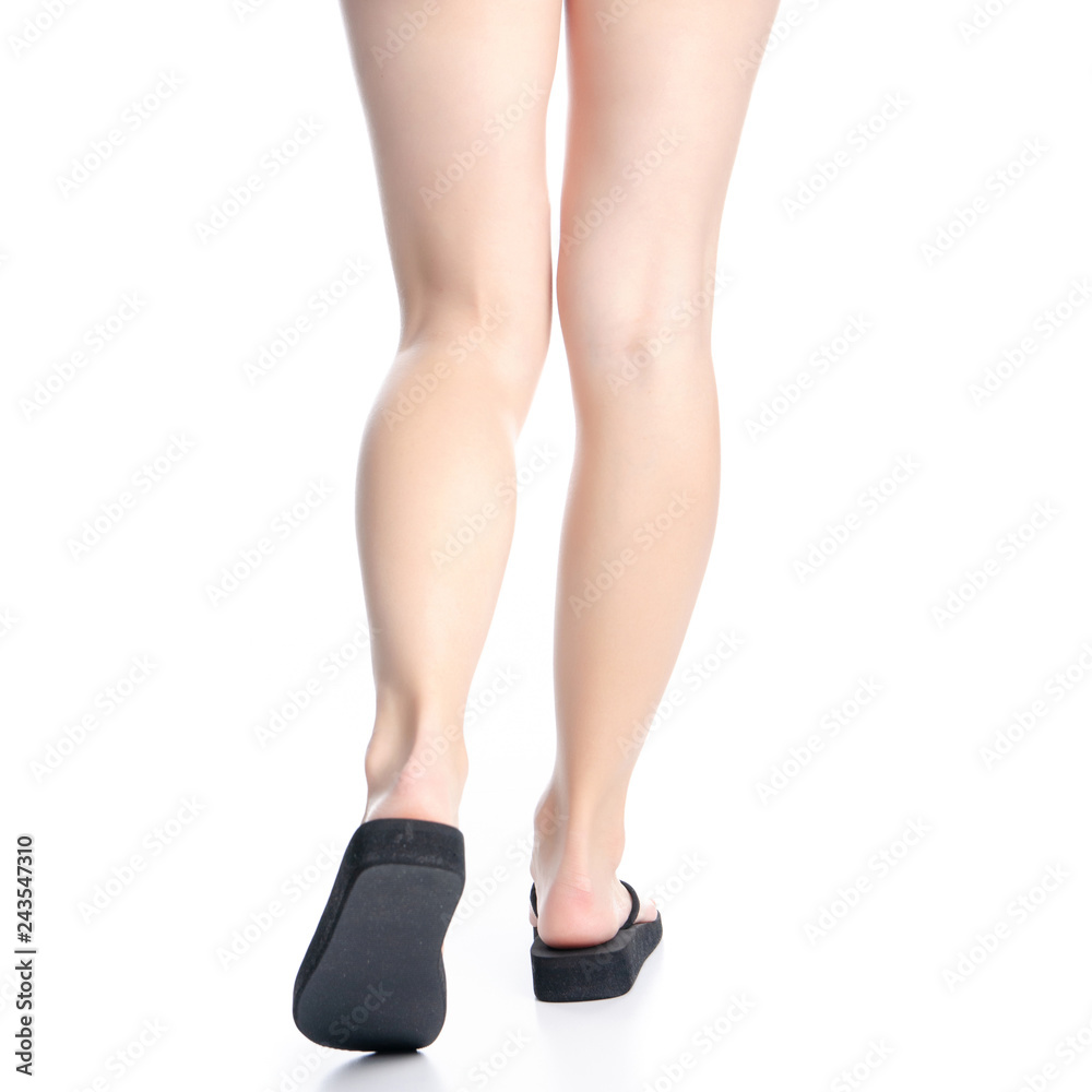 Woman legs in black flip flops on white background isolation, back view ...