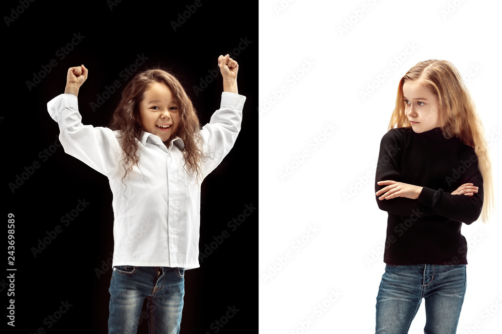 The portrait of emotional happy winner girl and serious girl on a white ...