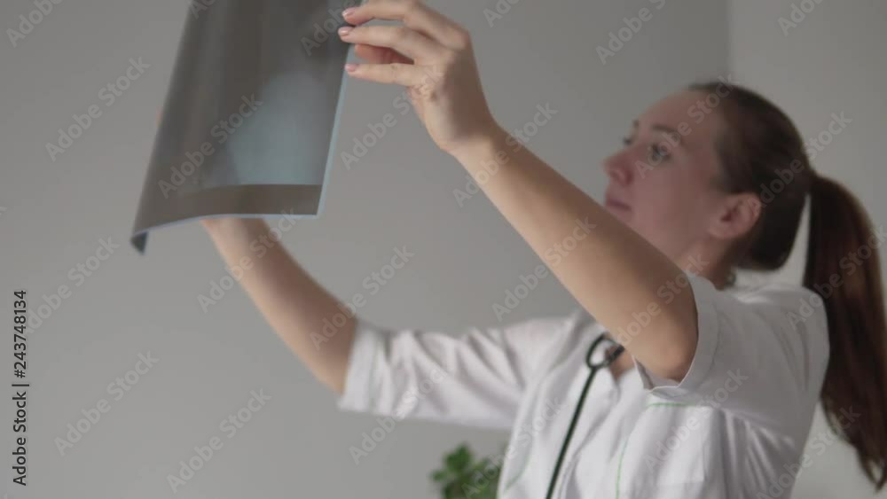 Female doctor examines picture rengenta chest. Medical staff looking ...