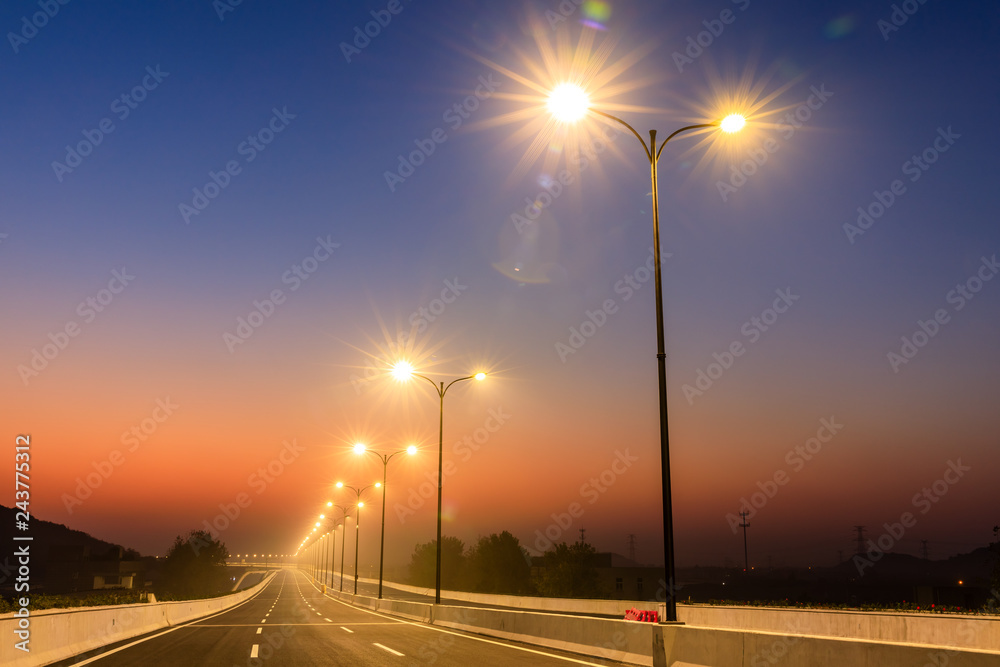 City road and bright street lights landscape at sunset Stock Photo ...