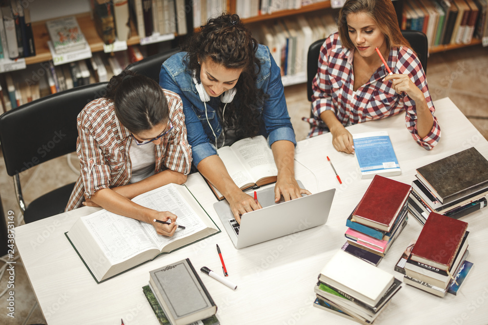 Cute female students study in the university campus library.Learning ...