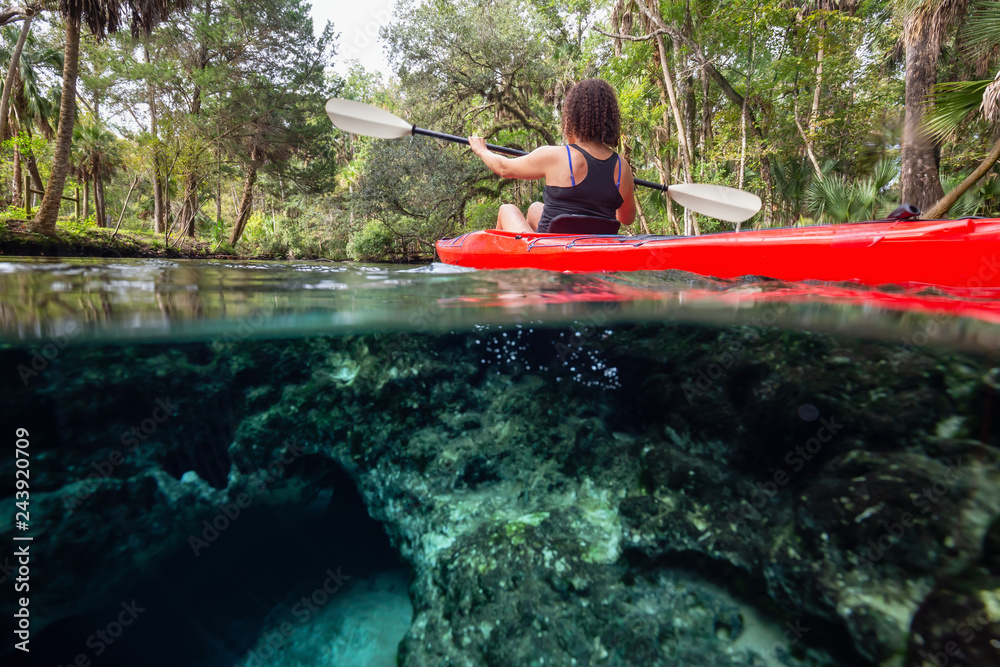 Over and Under picture of a girl kayaking in a lake near an underwater ...