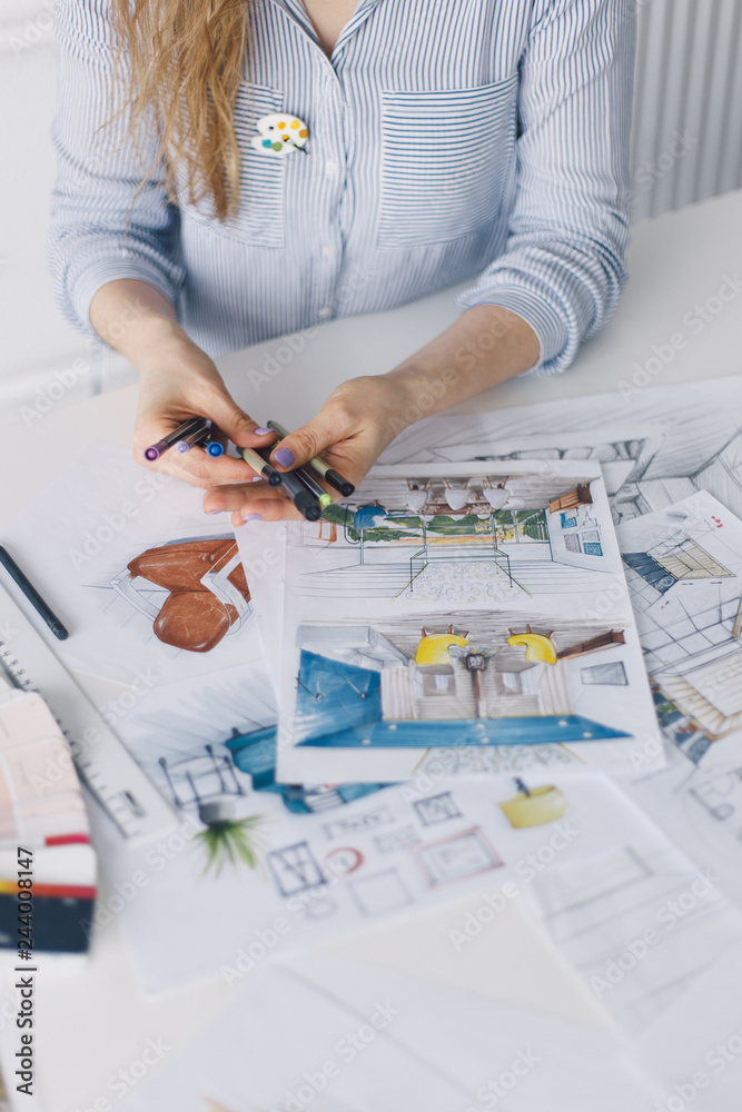 Interior designer works on a hand drawing sketch using color pencils ...
