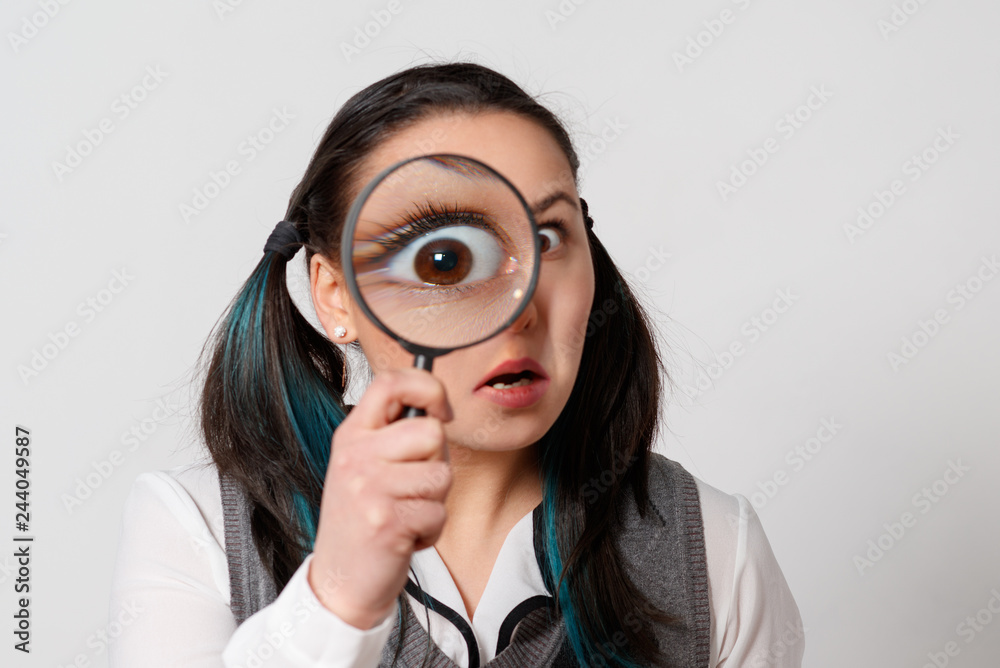 Portrait of a funny young woman looking at the camera through ...