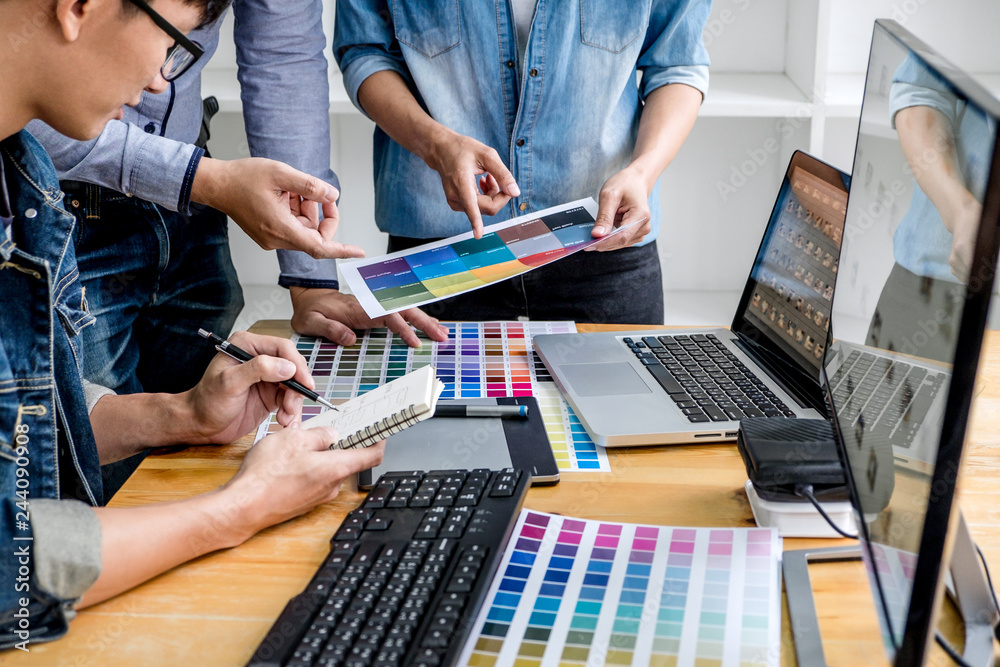 Foto de Team of young colleagues creative graphic designer working on ...