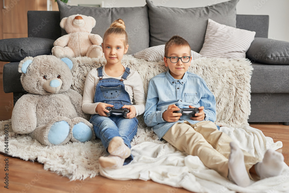 Children boy and girl playing on video games. Pretty little girl and ...