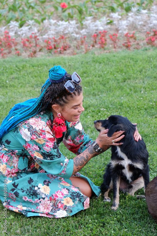 Cute girl smiling and cuddling stray dog in the park Stock Photo ...