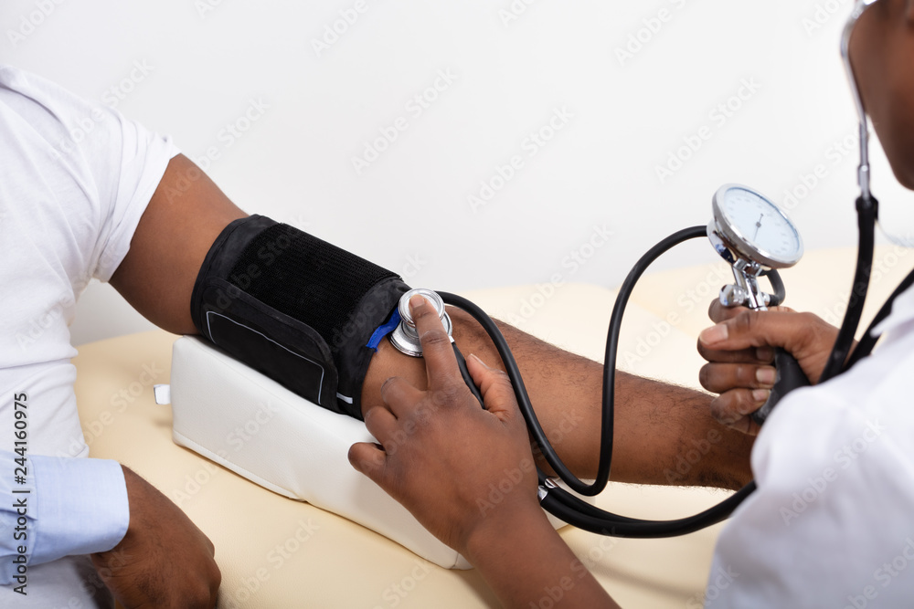 Doctor Measuring Blood Pressure Of Patient Stock Photo | Adobe Stock