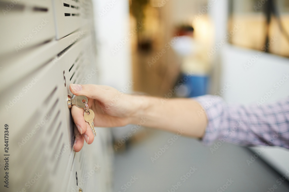 Hand of contemporary office manager locking or unlocking door of ...