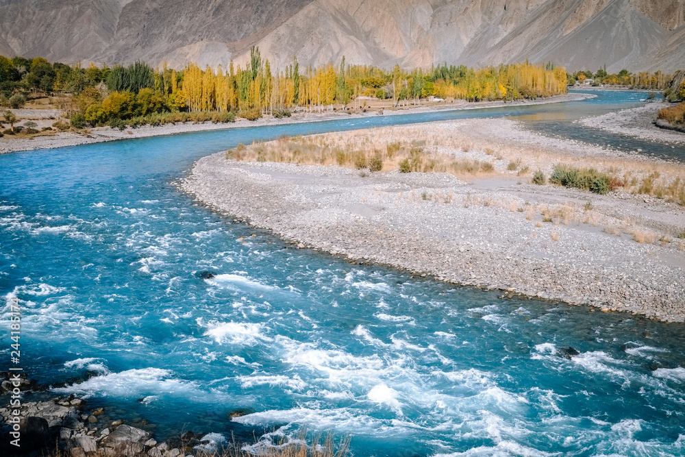 Autumn scene in Gupis. Turquoise blue water of Gilgit river flowing ...