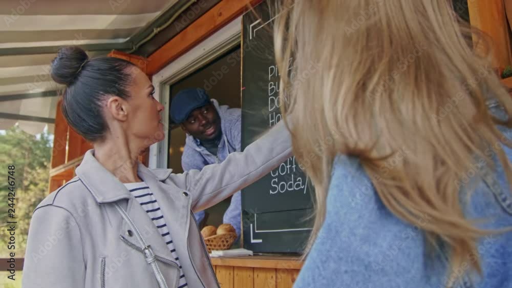 Over-the-shoulder shot of brunette Caucasian girl choosing menu by food ...