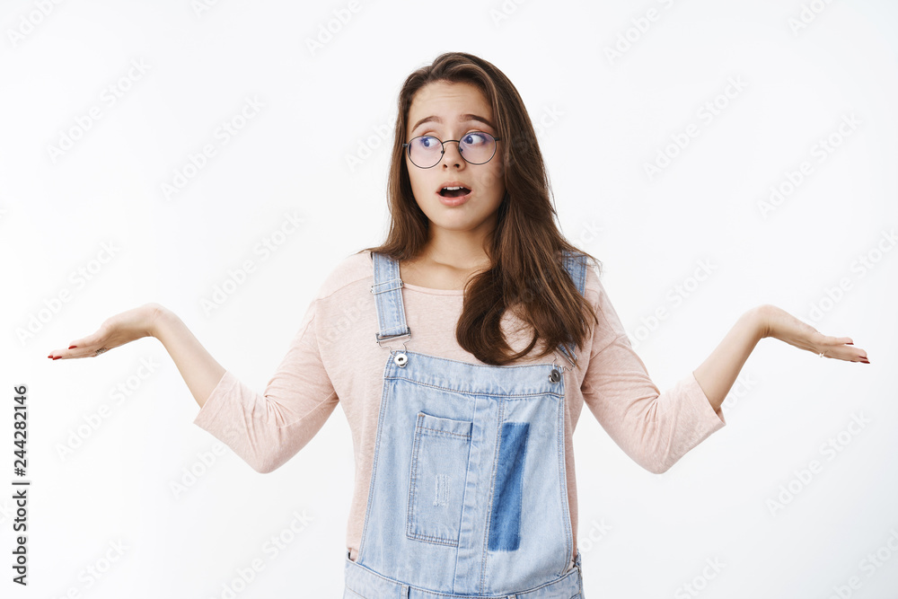 Clumsy and awkward silly young woman in glasses acting unaware and ...