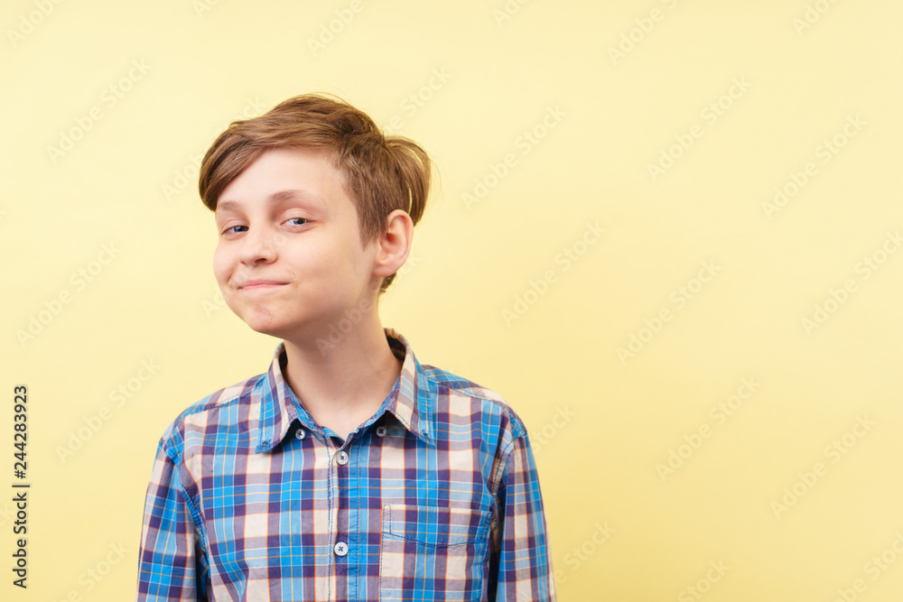 mocking jeering scoffing boy with ironical smile over yellow background ...