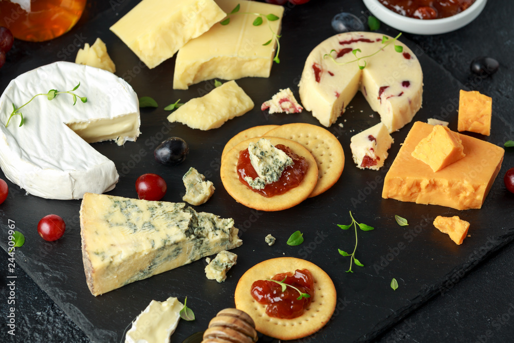Cheese platter served with grapes, ale chutney, honey, crackers on ...