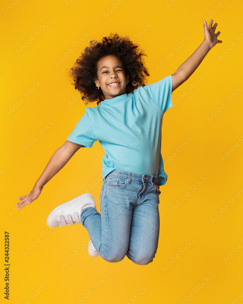 Little african-american girl jumping over studio background Stock Photo ...