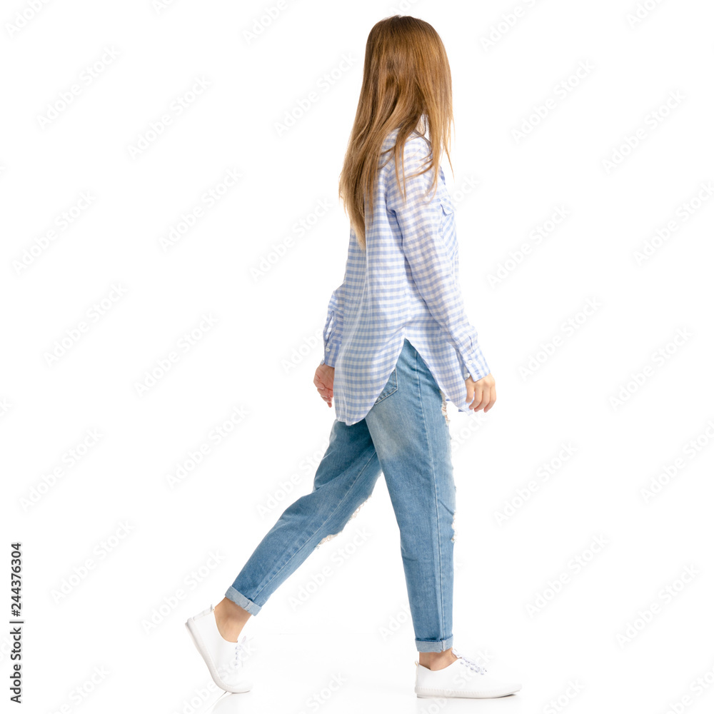 Woman in blue jeans and shirt goes on white background isolation, back ...