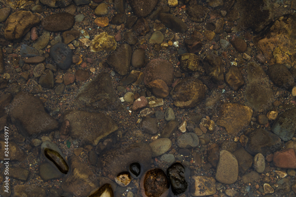 Stones in the river photographed from above / Clear river water and ...