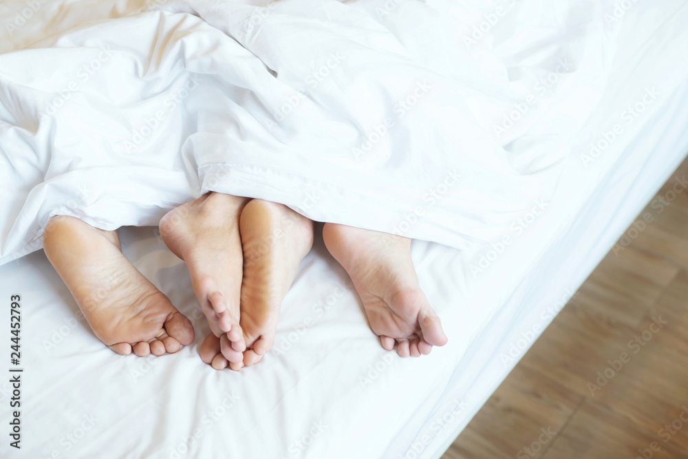 close up legs feet of two Lovers couple sleeping side by side embracing ...