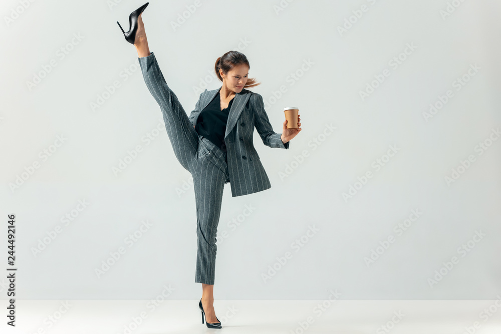 Happy business woman dancing and smiling in motion isolated over white ...