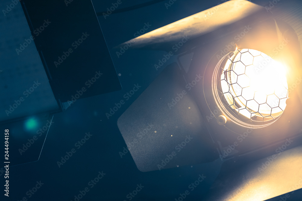 Professional orange studio spotlight in a TV studio. Lighted dust ...