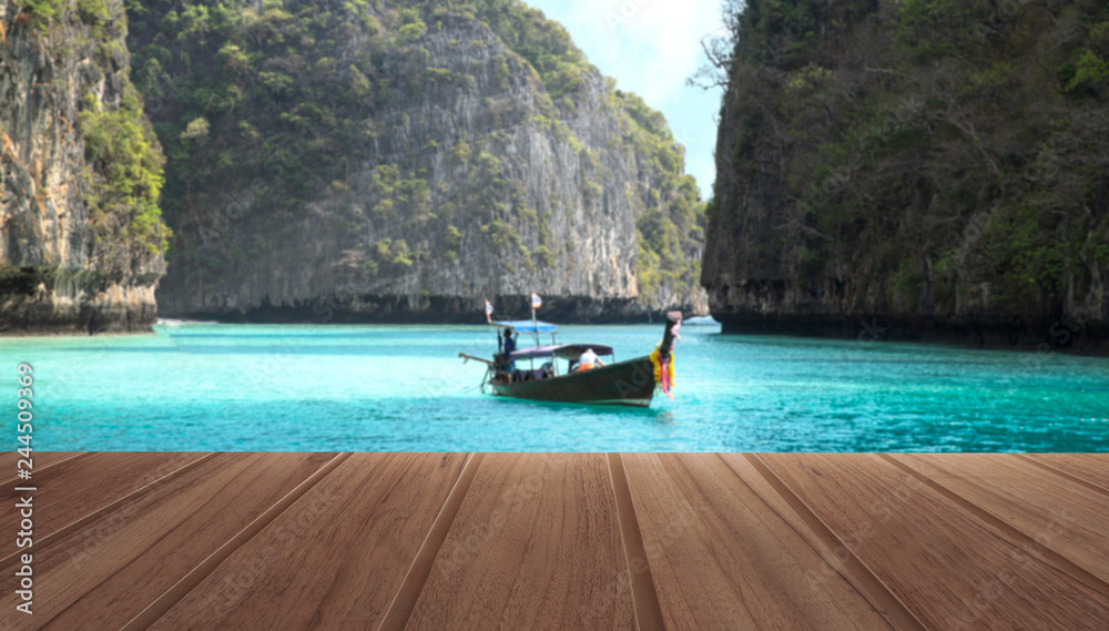 Wood top table on top view beautiful sea and wooden boat with mountain ...