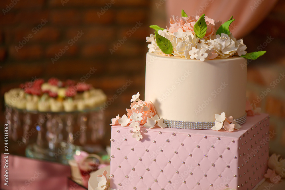 Large assortment of bite-sized cakes and a large three tiered cake ...