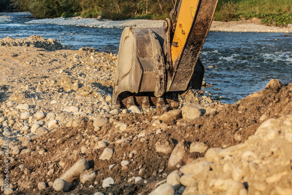 Excavator (digging machine) bucket digging ground by the river. Stock ...