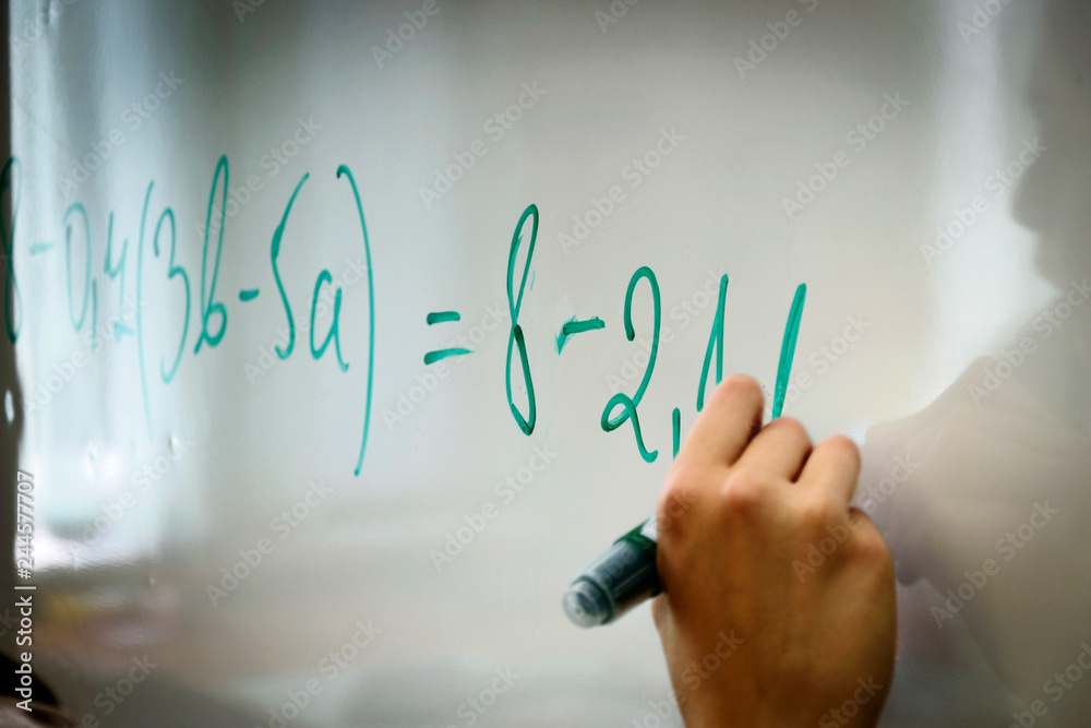 Education in high school, hand with green marker writes maths formula ...