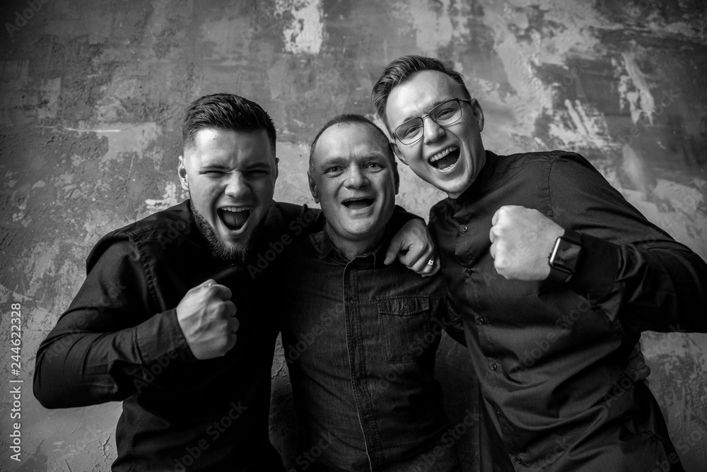 Father and his young sons. Two adult sons and their dad standing on ...