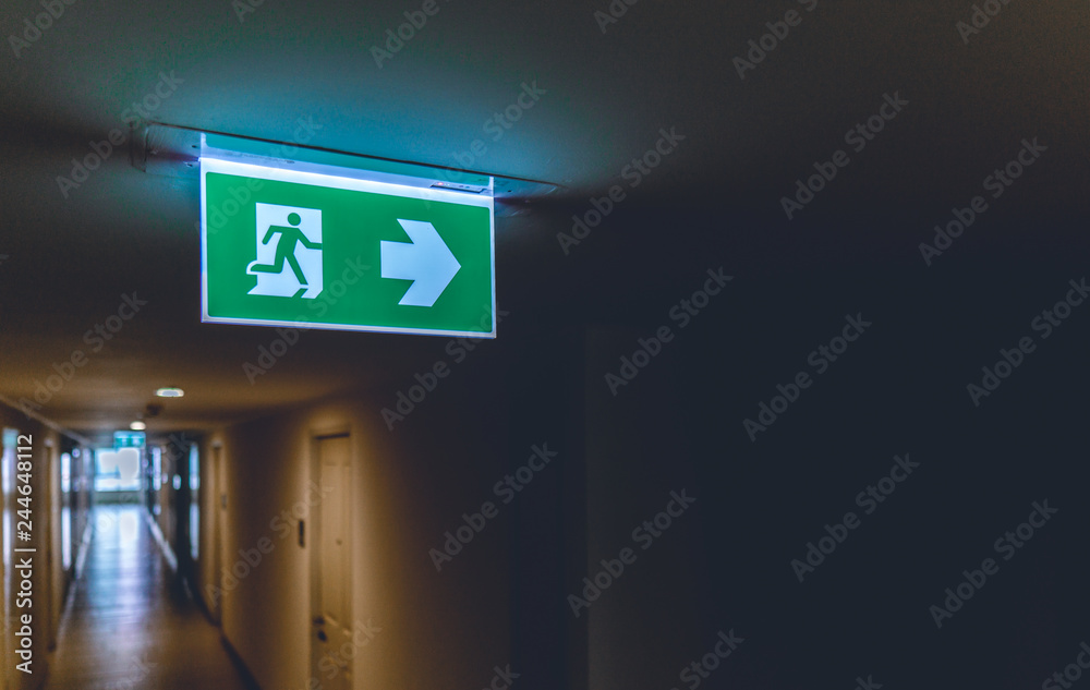 Emergency fire exit green sign at the corridor in office building ...