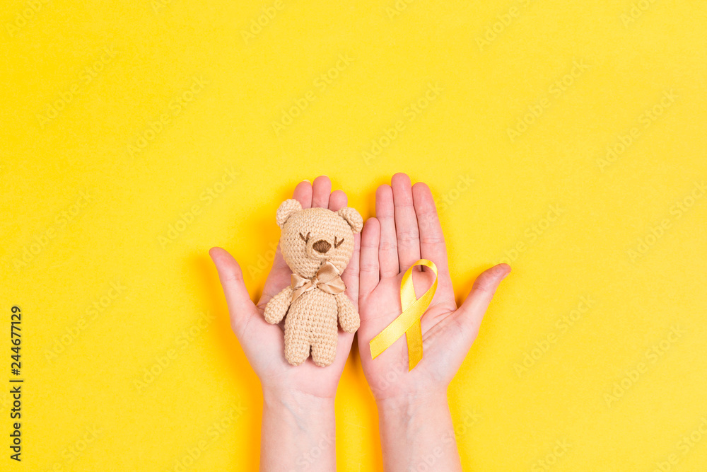 Girl hands holding children's toy with a Childhood Cancer Awareness ...