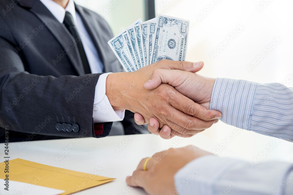 Businessman or politician taking bribe and Shaking Hands With Money in ...