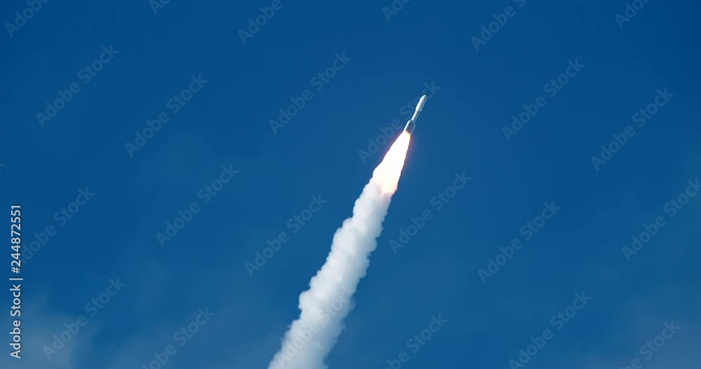 Space Rocket flying against deep blue sky with bright flames and dense ...