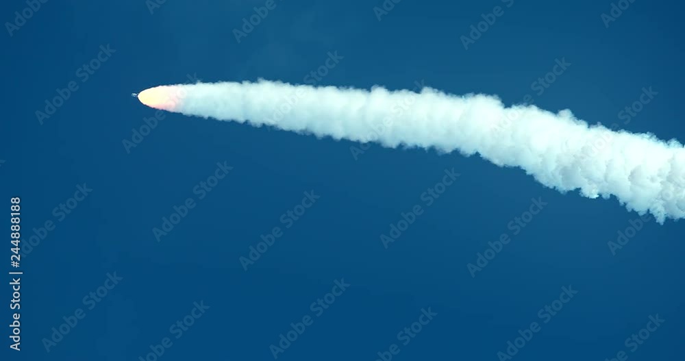 Space Rocket at high altitude flying through deep blue sky with bright ...