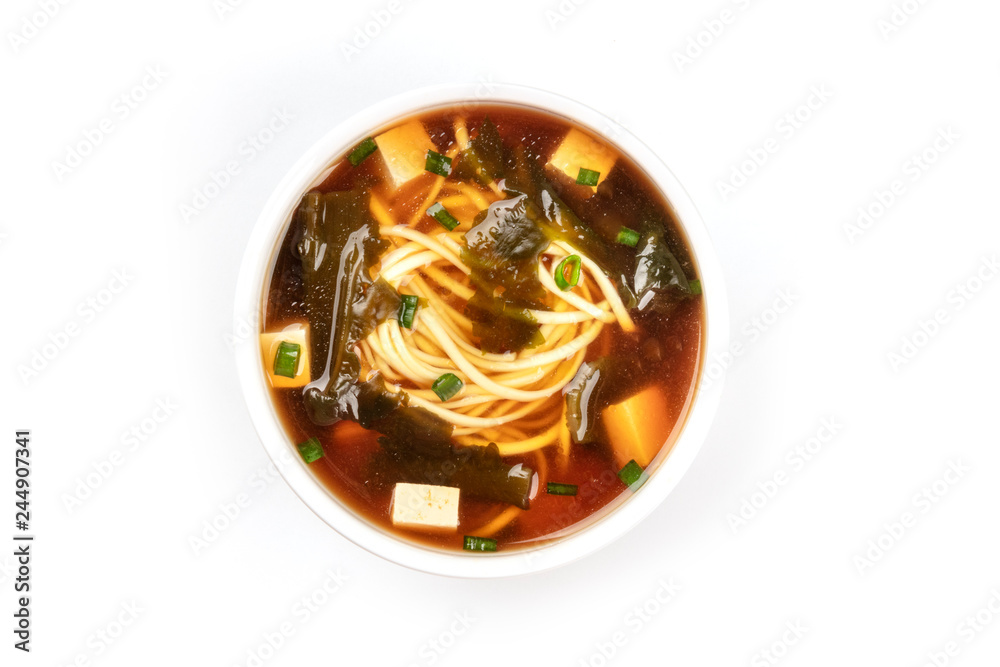 A photo of a bowl of miso shiru soup with tofu, scallions, noodles, and ...