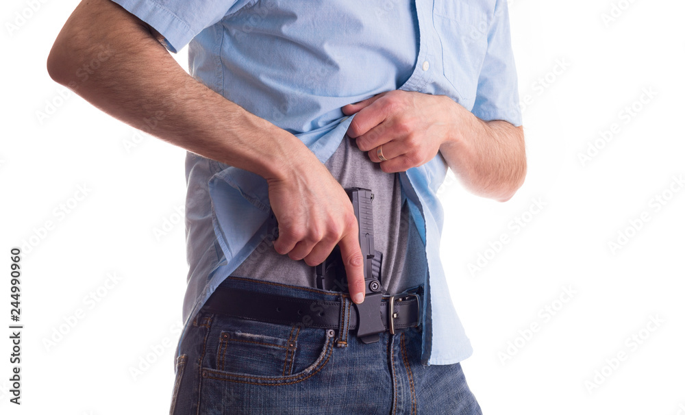 Man drawing concealed carry pistol Stock Photo | Adobe Stock