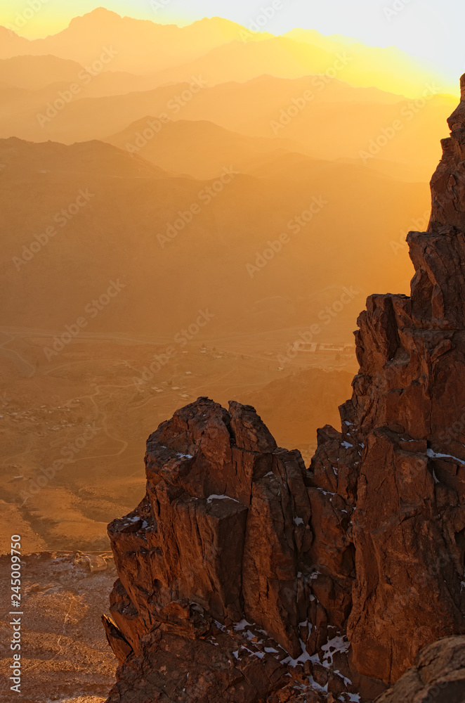 The sun rises behind the rock. Mysterious landscape of Mount Sinai ...