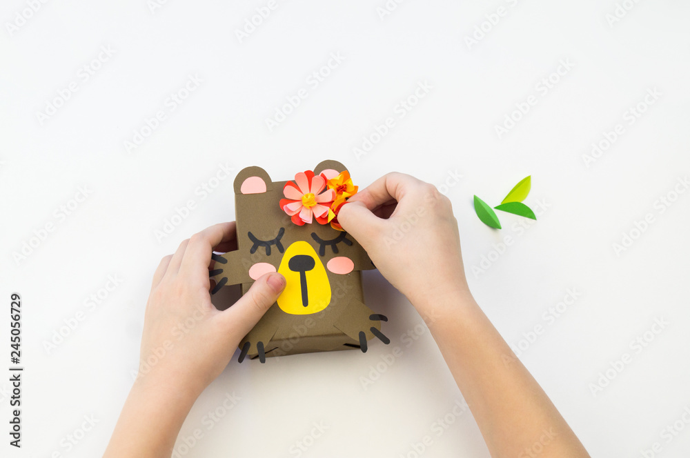 Child making gift a bear box. Teddy bear out of paper craft. Packaging ...