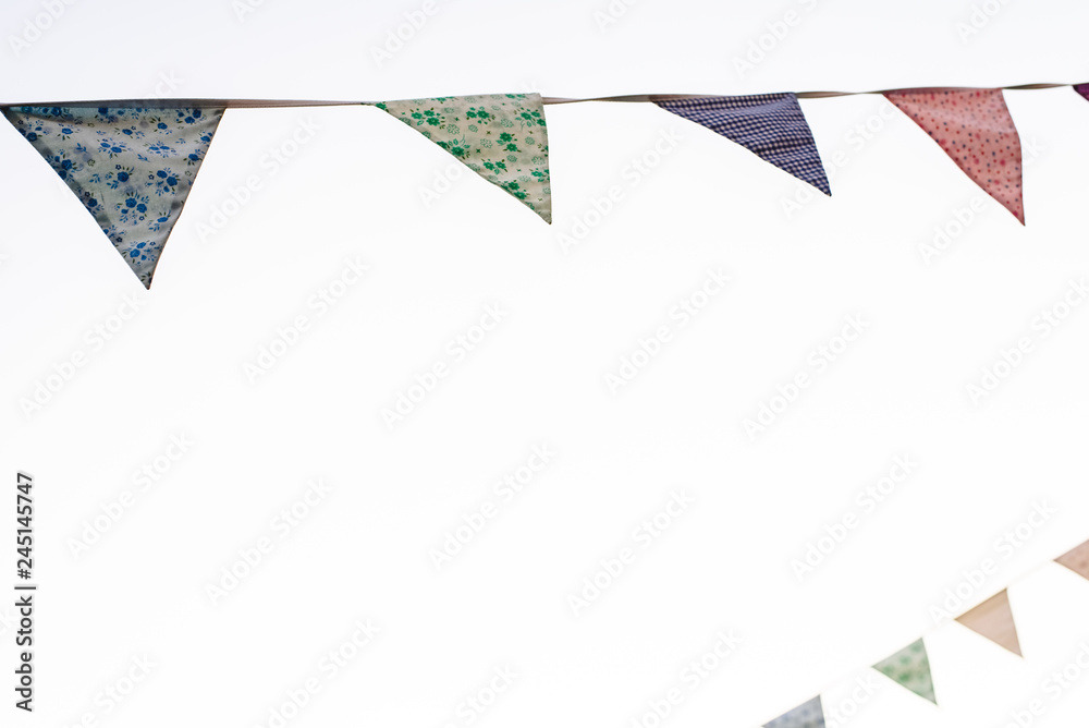 Pennants with blue sky background and pale colors hanging on a rope ...