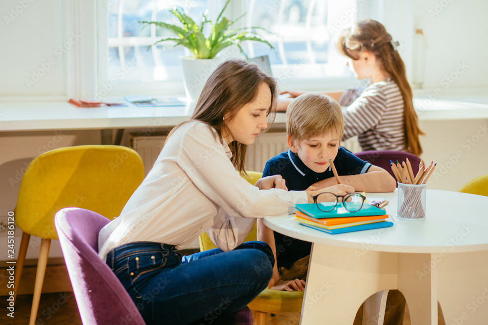Сhildren of different ages working together at library interior. Young ...