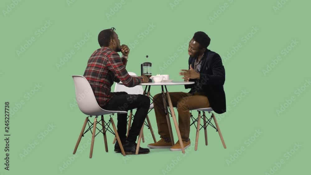 Two African men sitting at a table in a cafe and talking. Transparent ...