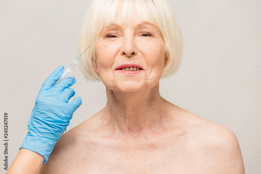 Senior woman getting skin care injection. Aged lady having botox ...