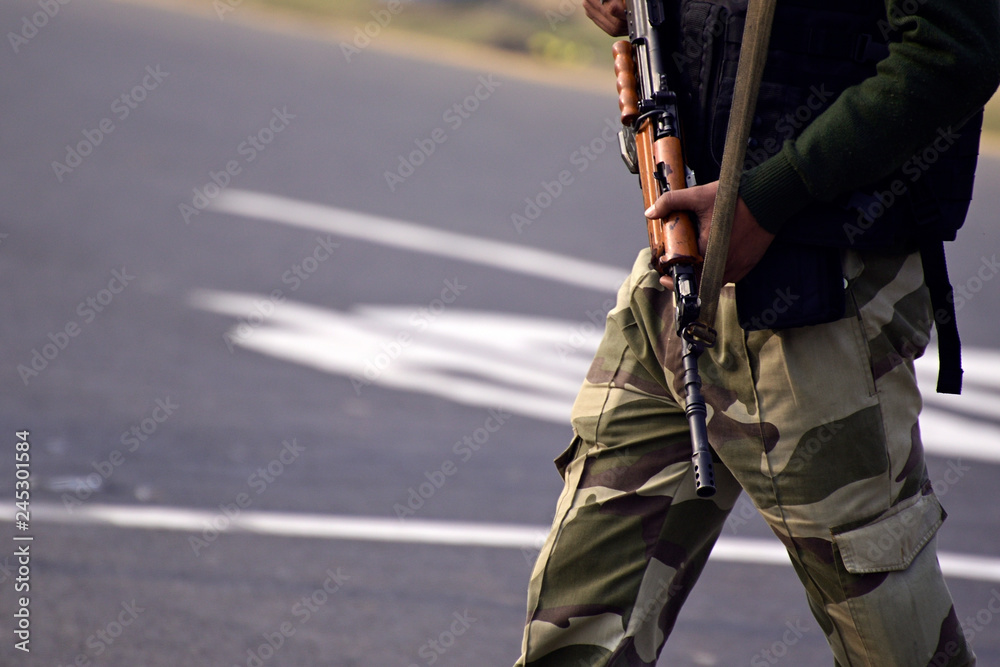 Security guard with rifle standing on outside to protect the area ...