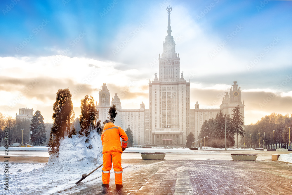 person cleaning snow on street of moscow city historical skyline ...